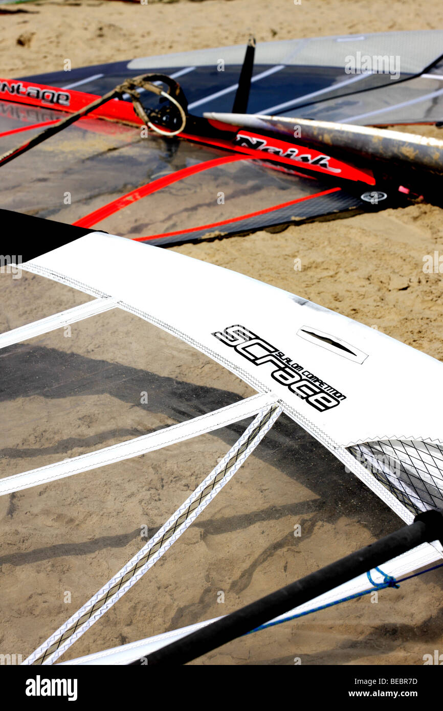 Colourful Windsurfing Boards And Sails Laying On A Sandy Beach Waiting ...