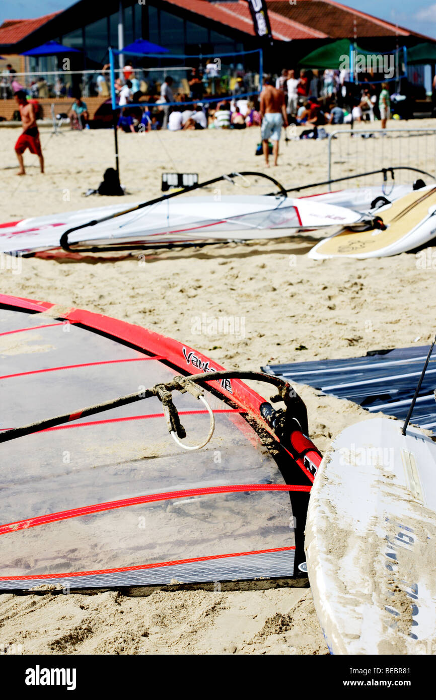 Colourful Windsurfing Boards And Sails Laying On A Sandy Beach Waiting ...