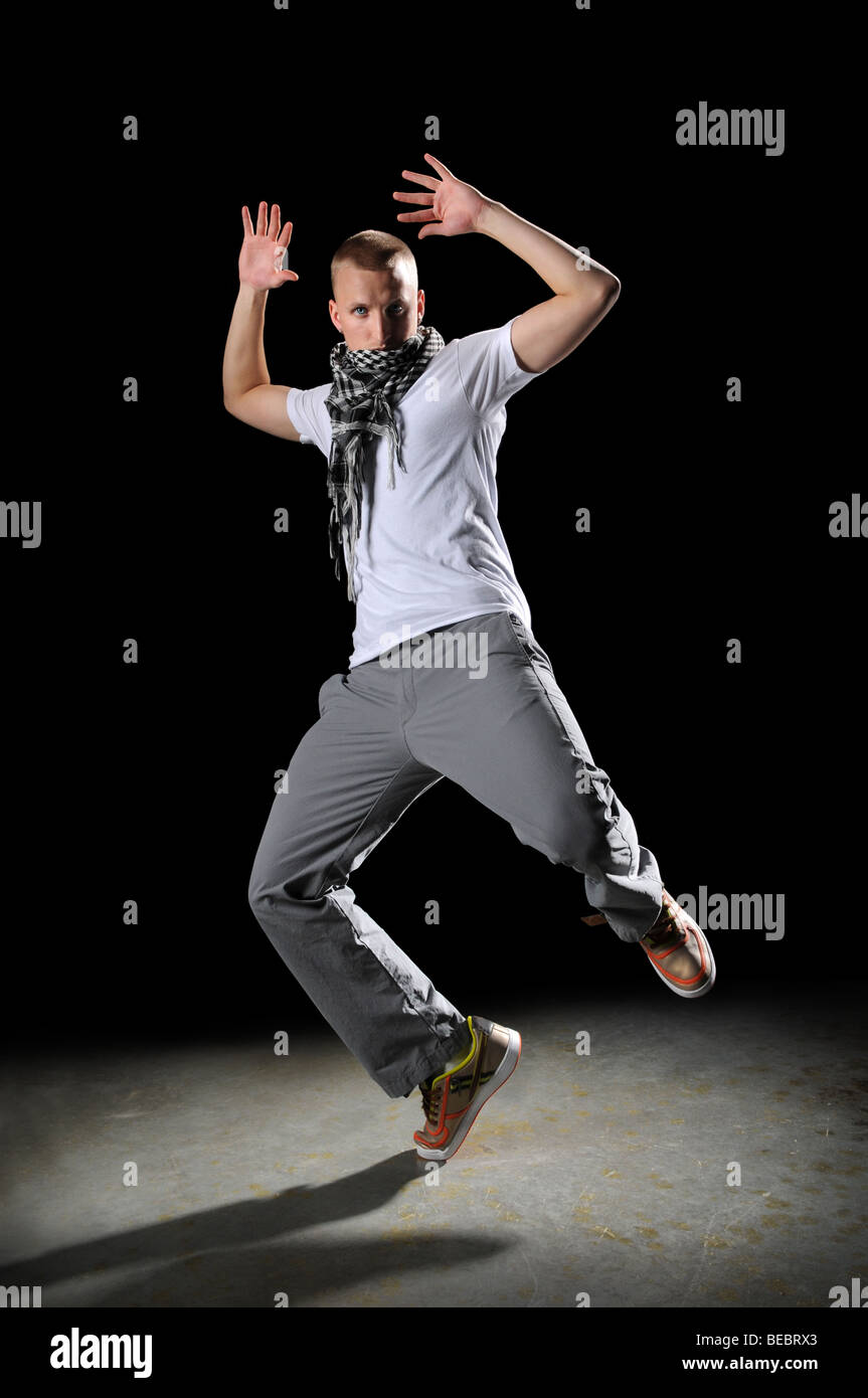 Portrait of hip hop young man dancing over dark background Stock Photo ...
