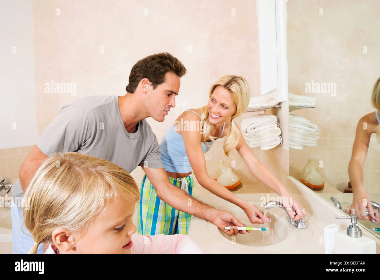 Couple rinsing off their toothbrushes under the faucet Stock Photo - Alamy