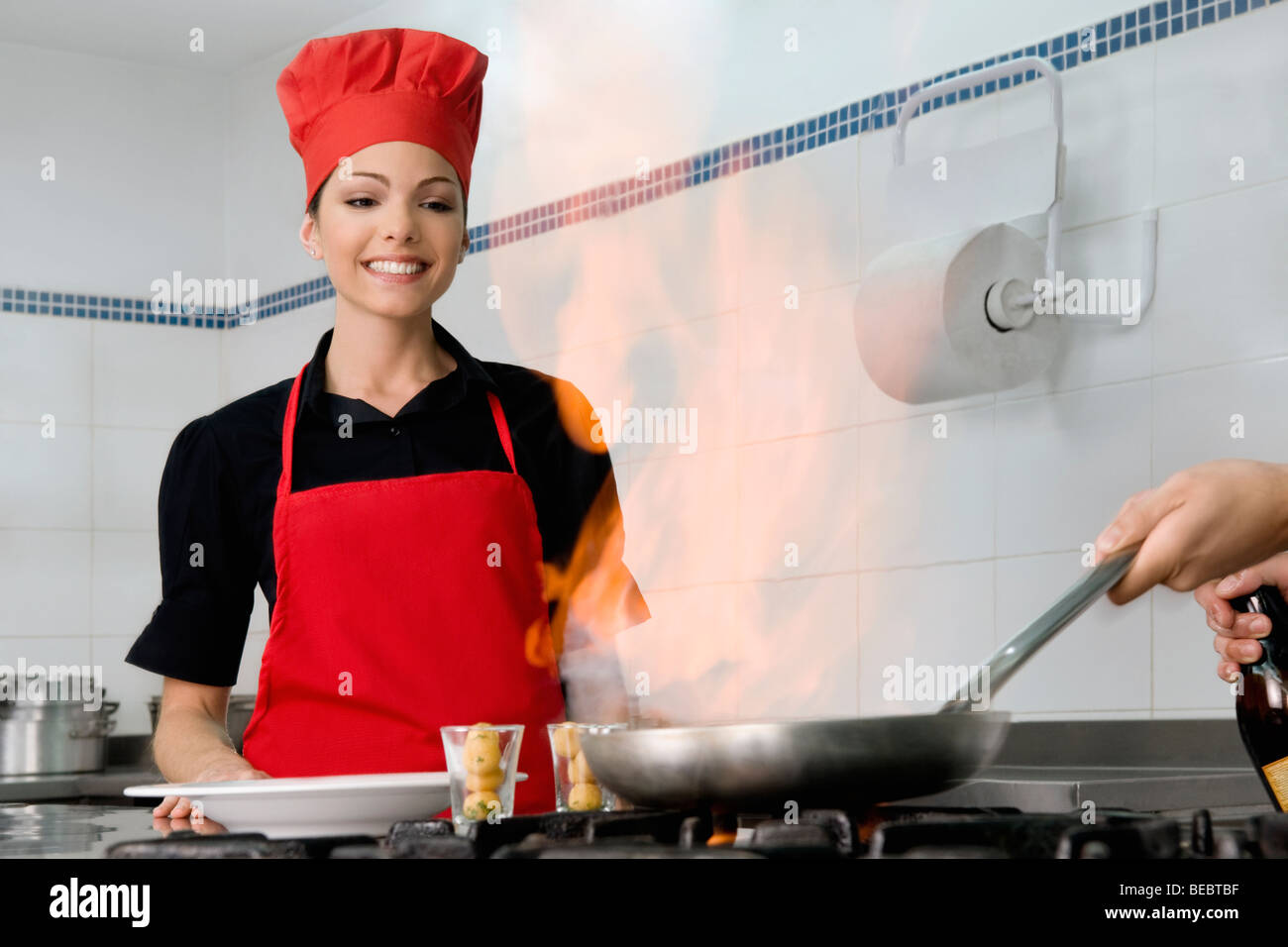 Female chef cooking food in the kitchen Stock Photo - Alamy