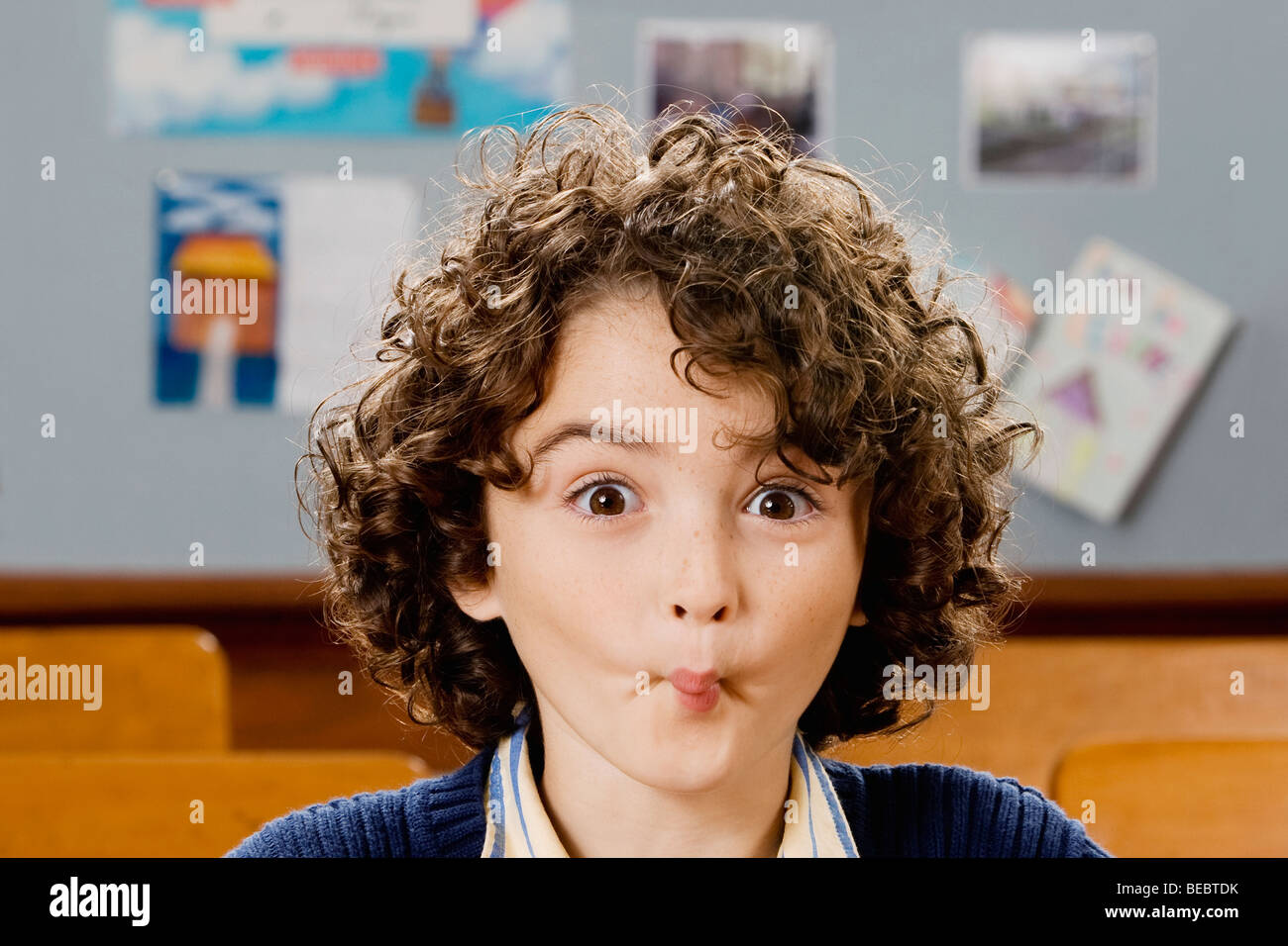 Schoolboy making a funny face in a classroom Stock Photo - Alamy