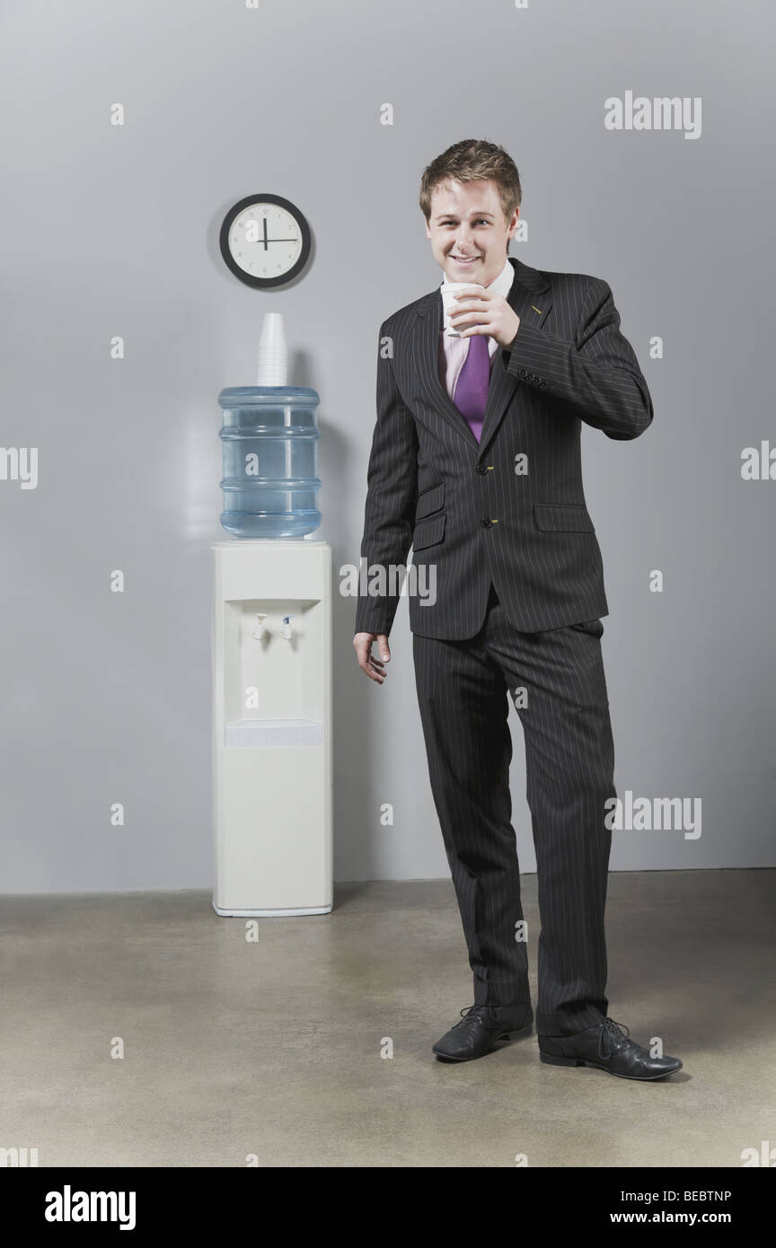 Portrait of a businessman standing near a water cooler Stock Photo - Alamy
