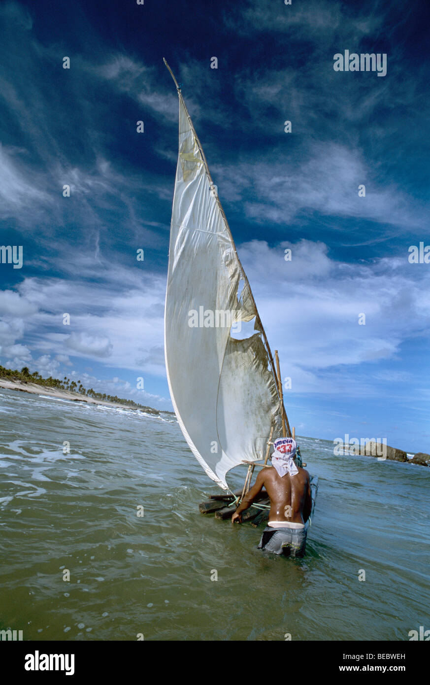 Traditional fisherman pulling raft into ocean, Recife, Brazil ...