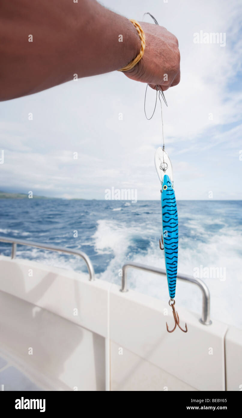 Man holding a fishing bait on a boat Stock Photo - Alamy