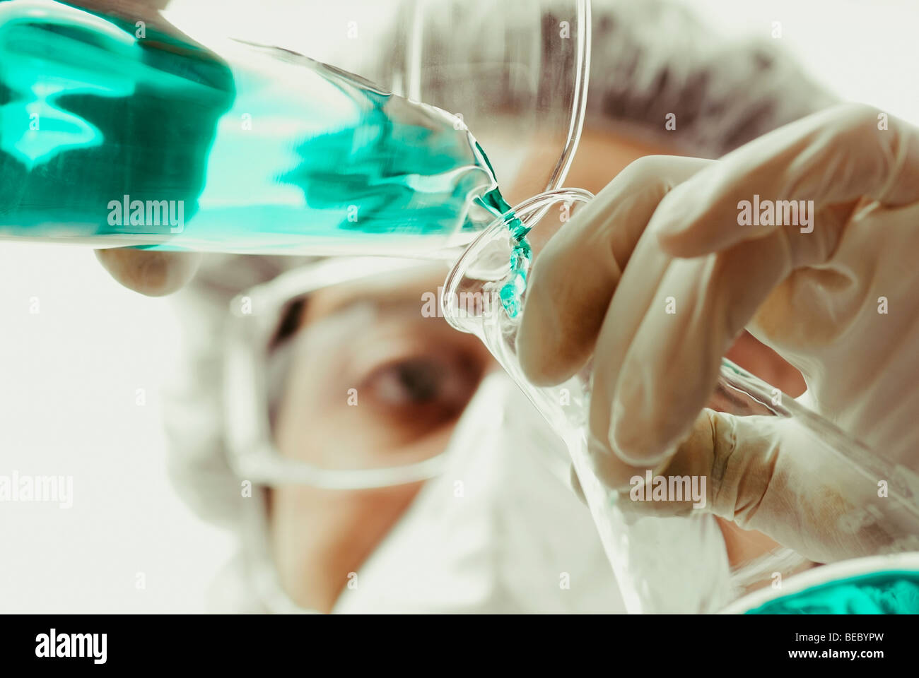 Scientist pouring liquid into a conical flask Stock Photo - Alamy