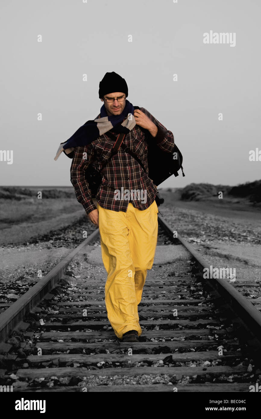 Man walking on a railroad track Stock Photo - Alamy