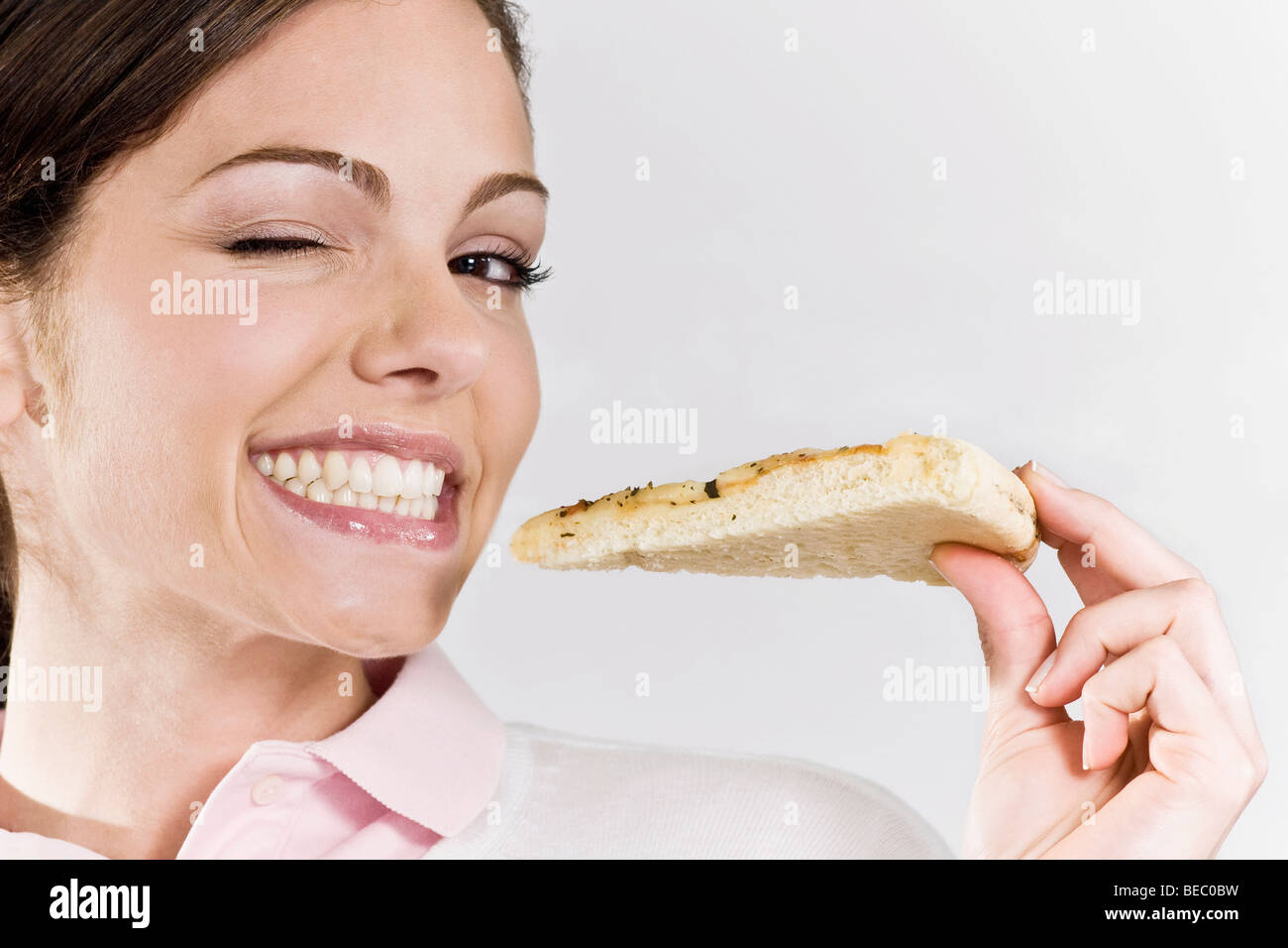 Female chef eating a pizza and winking Stock Photo - Alamy