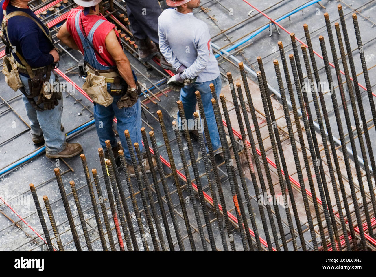 High angle view of four construction workers standing at a construction ...