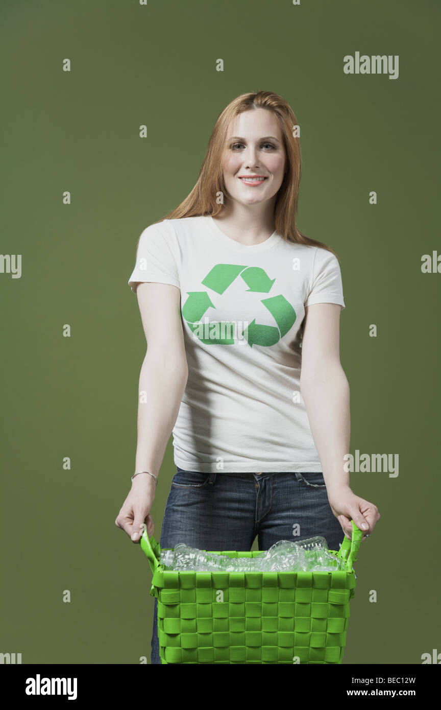 Portrait of a woman holding a recycling bin and smiling Stock Photo - Alamy