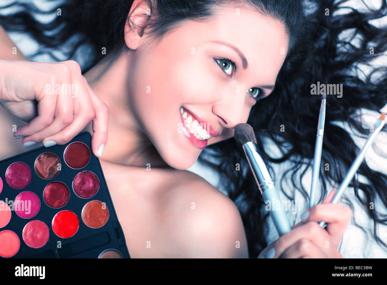 Makeup artist with brushes and eye shadows portrait. Contrast colors ...