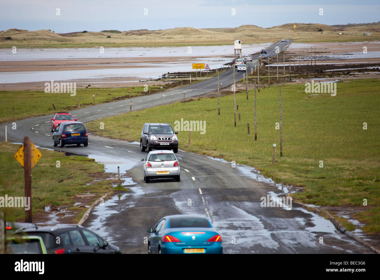 Causeway tide road path with cars at Lindisfarne Holy Island UK ...