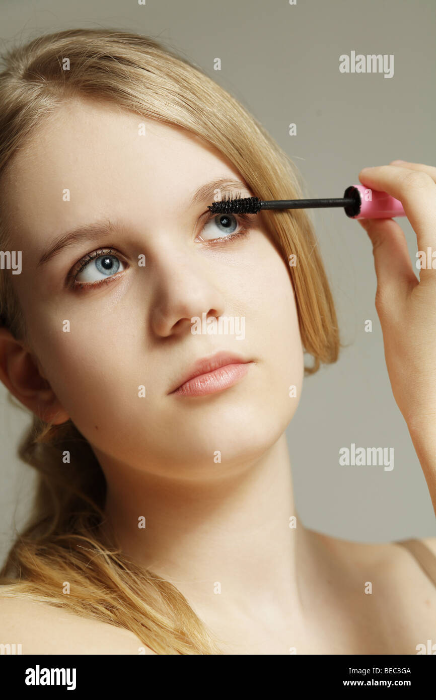 Teenage girl applying mascara on eyelashes Stock Photo - Alamy