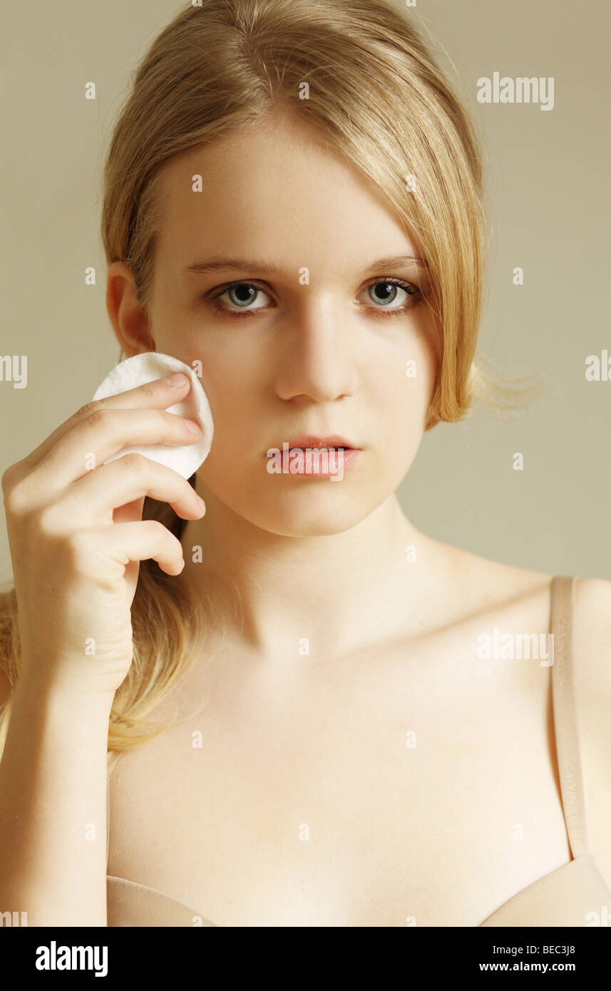 Teenage girl cleansing face with cotton pad Stock Photo - Alamy