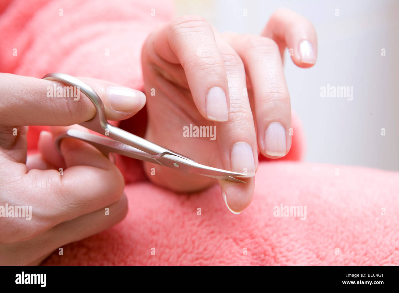 Young woman is cutting nails with scissors Stock Photo - Alamy