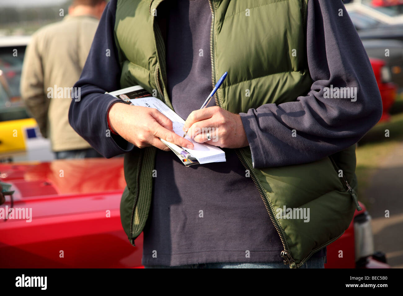 Man at an event buying a charity raffle ticket Stock Photo - Alamy