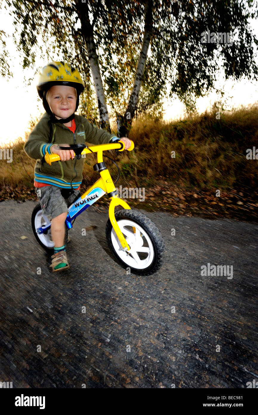 Child boy cycling through a forest bicycle ride with bike helmet Stock ...