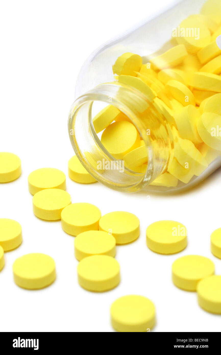 yellow pills and transparent bottle isolated on white Stock Photo - Alamy