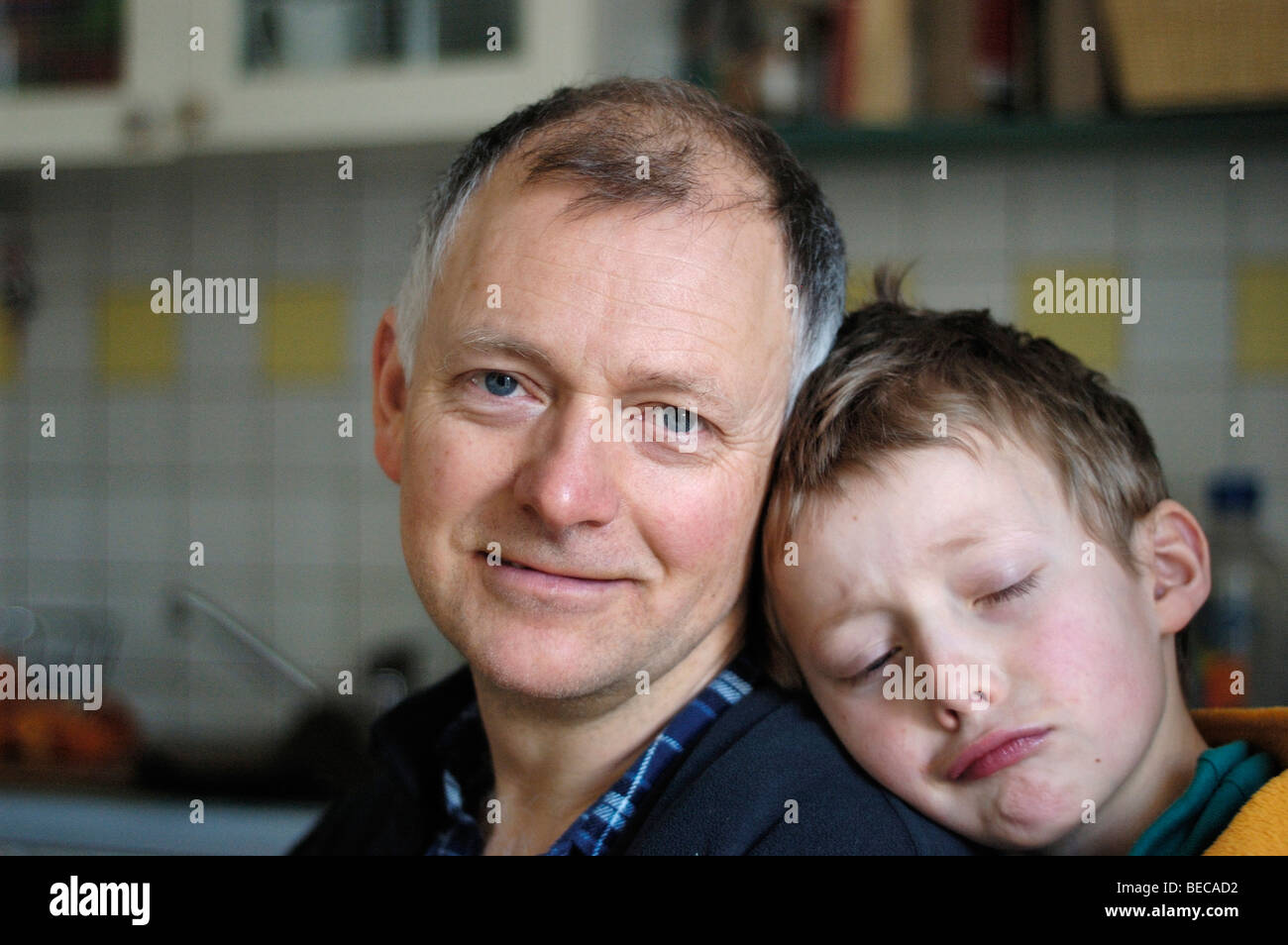 Little boy, 8, leaning against his father's shoulder Stock Photo - Alamy