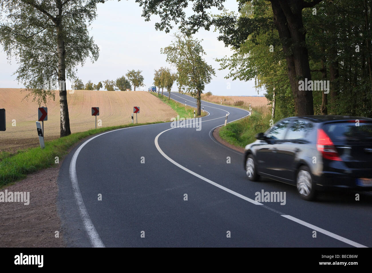 Dangerous double bend with car Stock Photo - Alamy