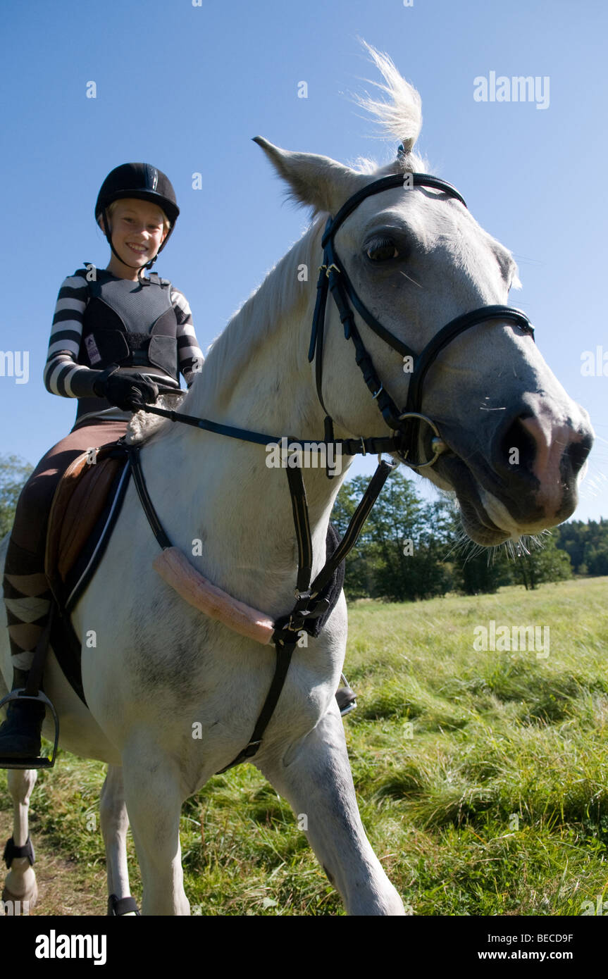 Girl riding on a white pony with ponytail Stock Photo - Alamy