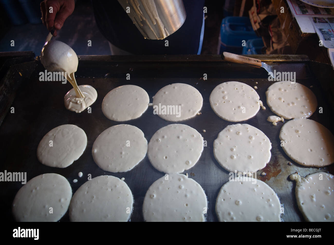 Ladle pouring one last pile of pancake mix on a large grill Stock Photo ...