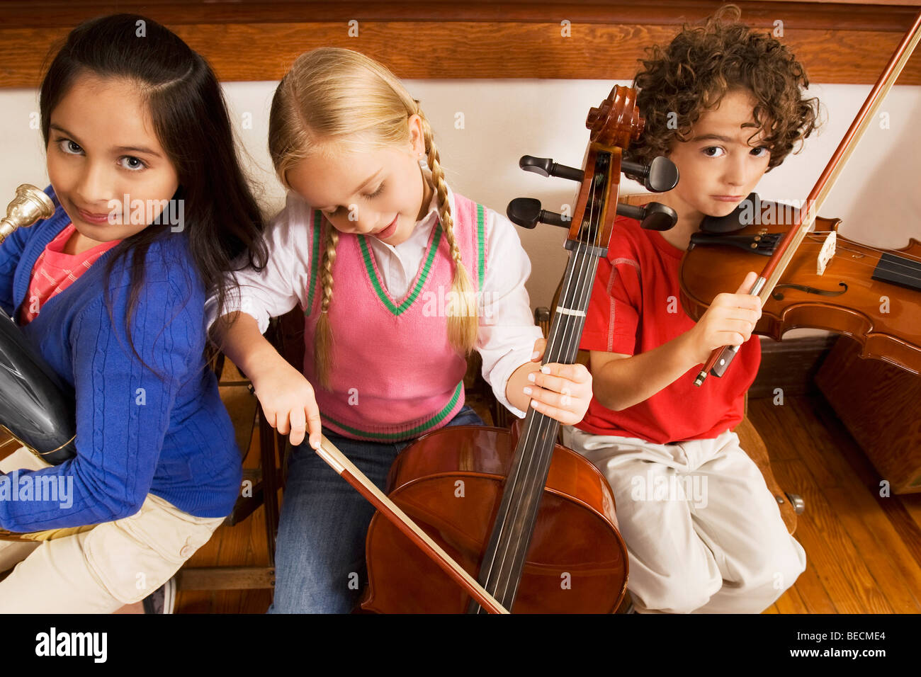 Three students playing musical instruments in a classroom Stock Photo ...
