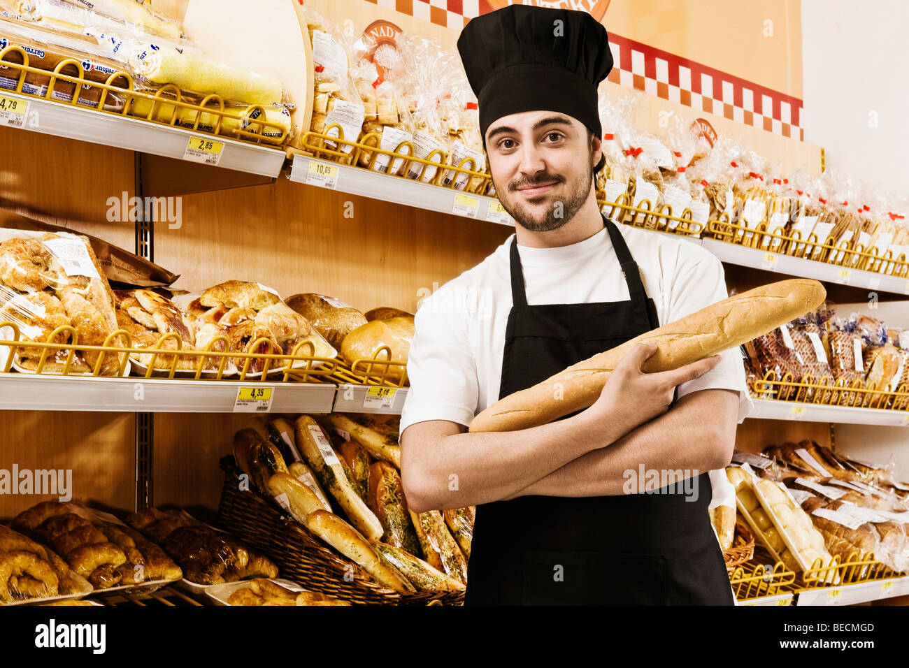 Salesman holding a loaf of bread in a supermarket Stock Photo - Alamy
