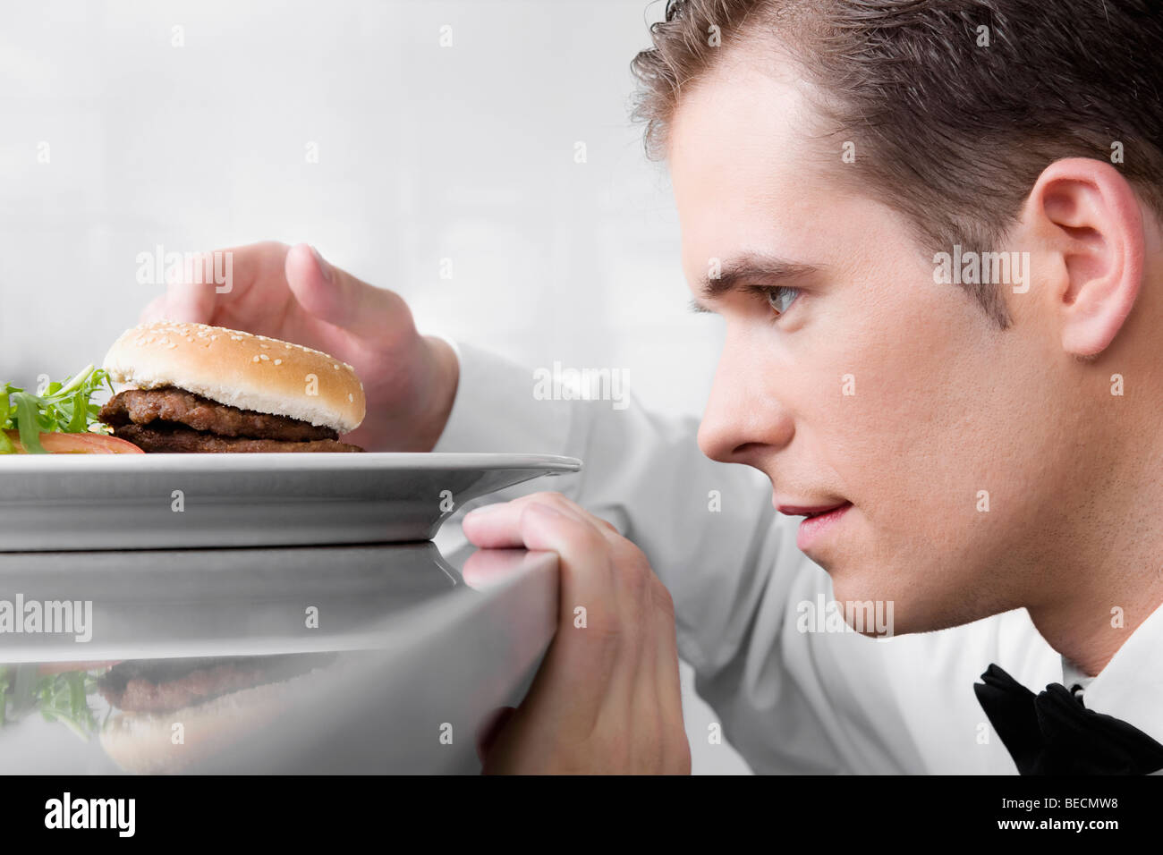 Close-up of a waiter holding a burger Stock Photo - Alamy