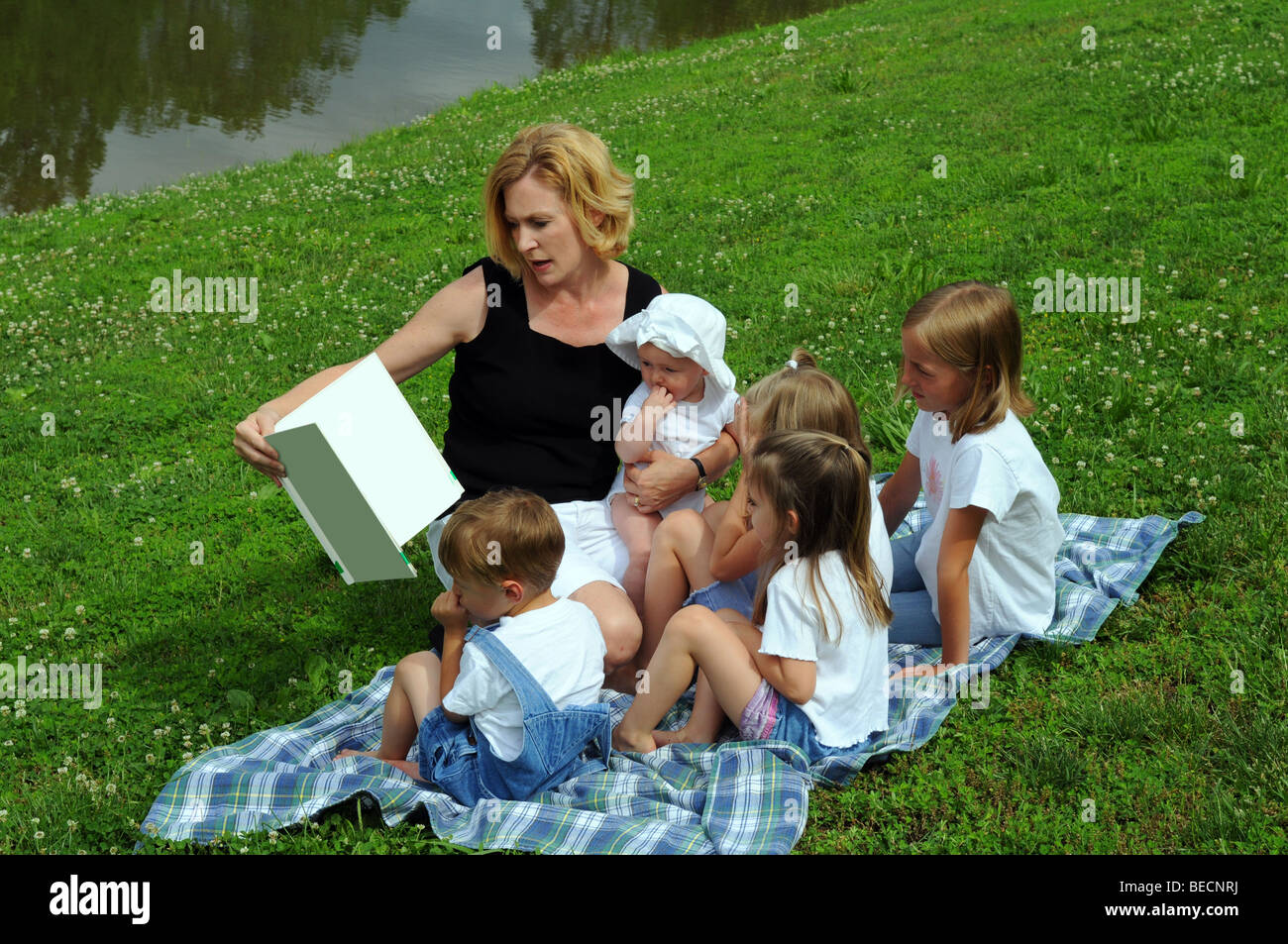 Mother reading book to children outdoors Stock Photo - Alamy