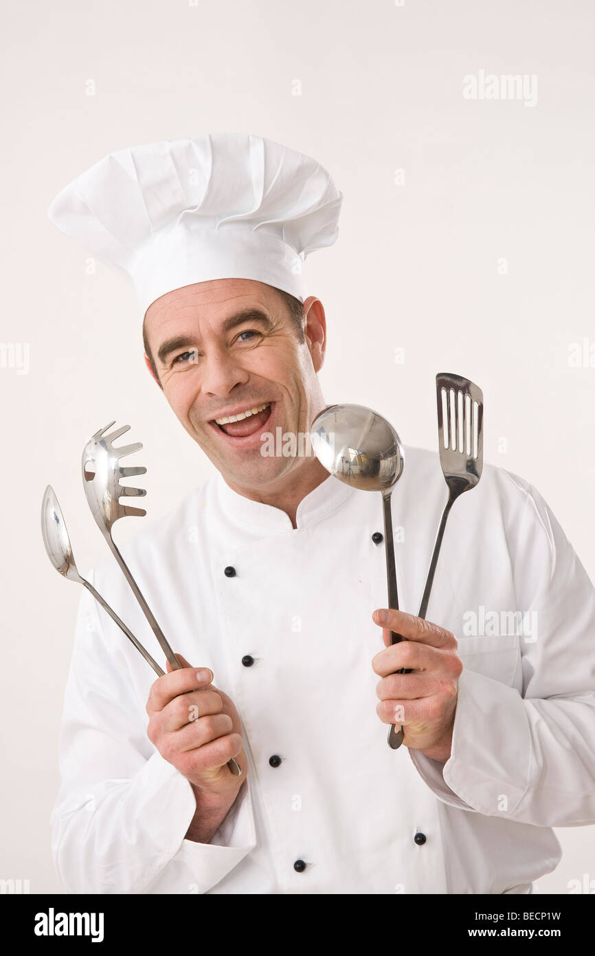 Cook laughing, holding cooking utensils Stock Photo - Alamy
