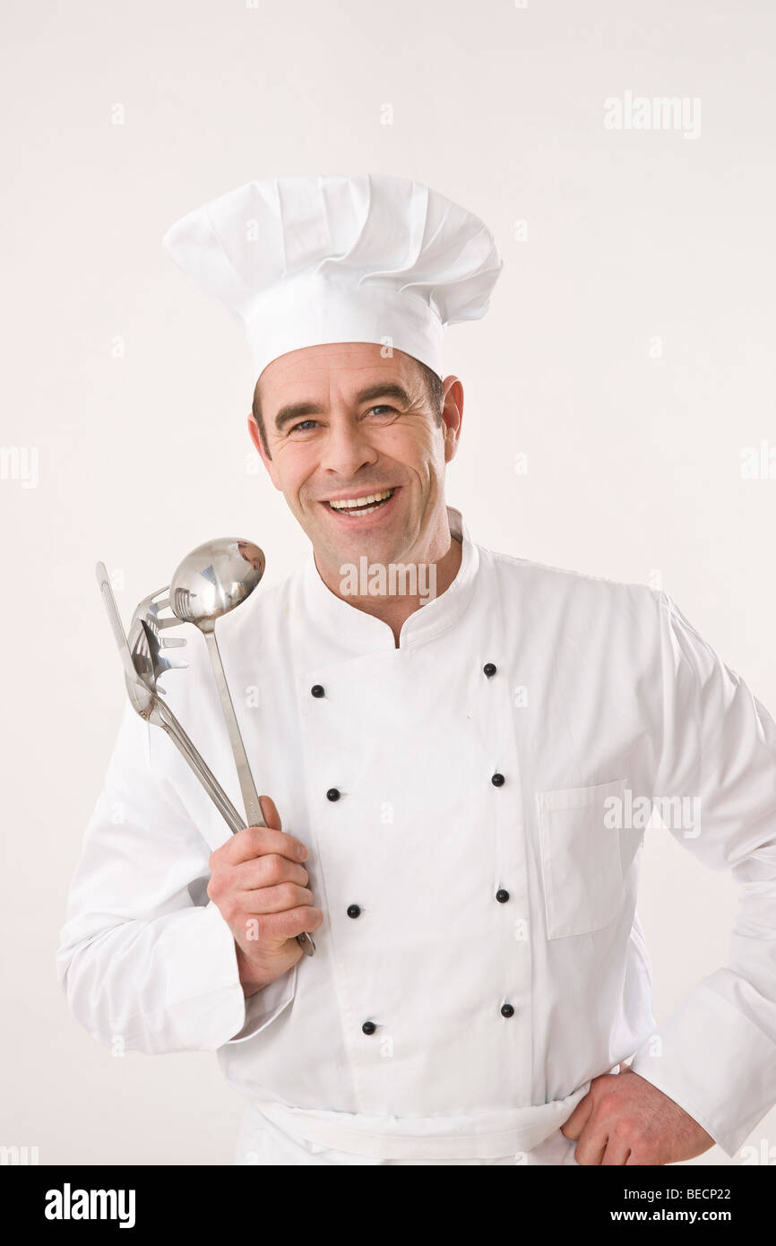 Cook laughing, holding cooking utensils Stock Photo - Alamy