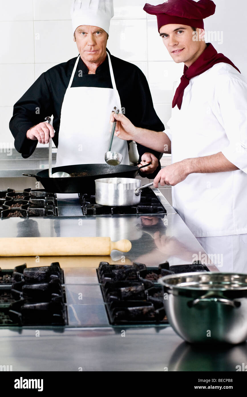 Two chefs cooking food in the kitchen Stock Photo - Alamy