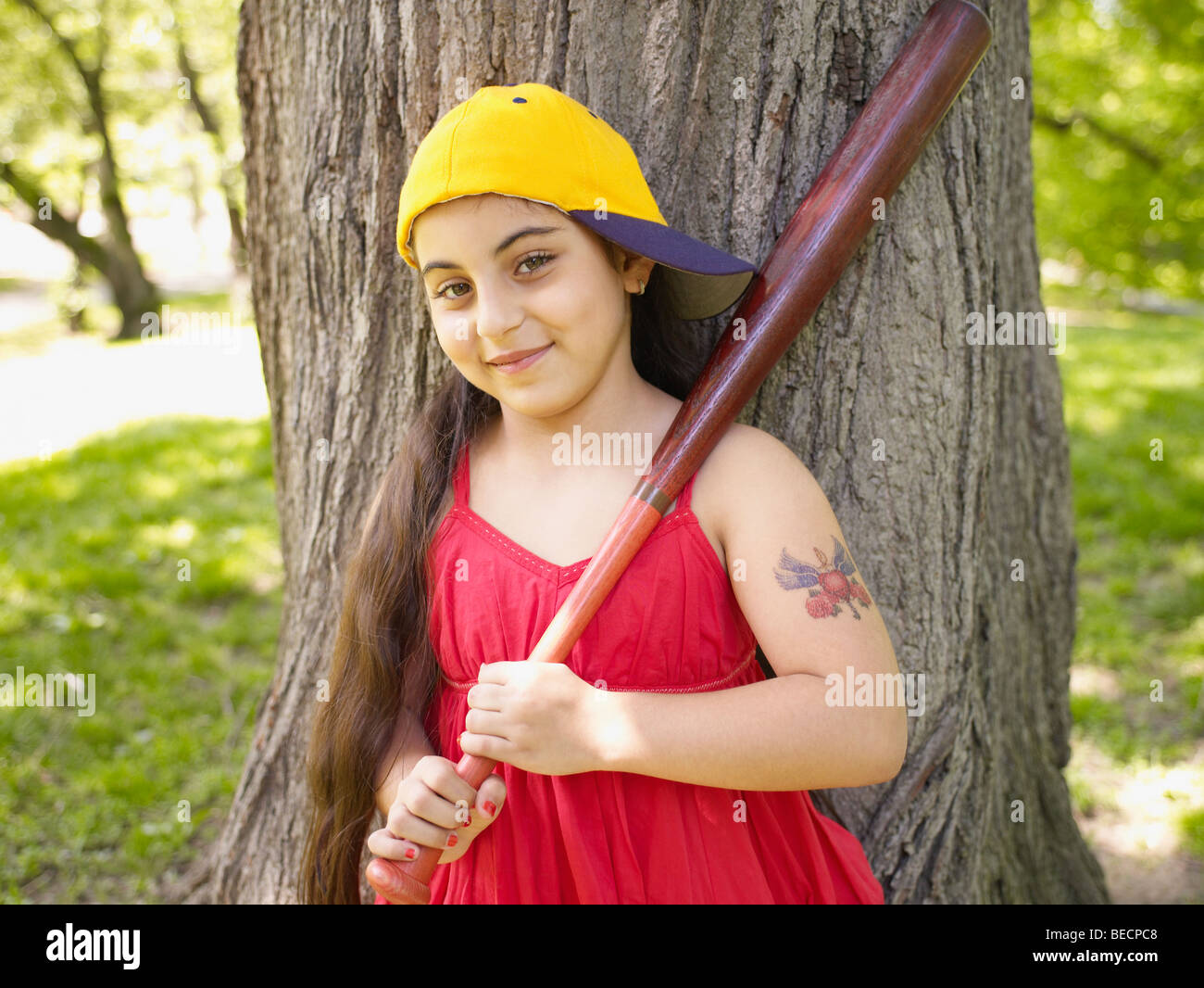 Smiling mixed race girl holding baseball bat Stock Photo - Alamy