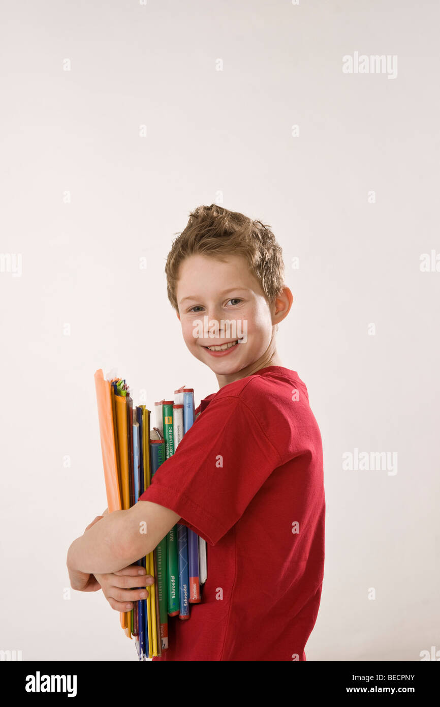 Boy carrying a pile of school books Stock Photo - Alamy