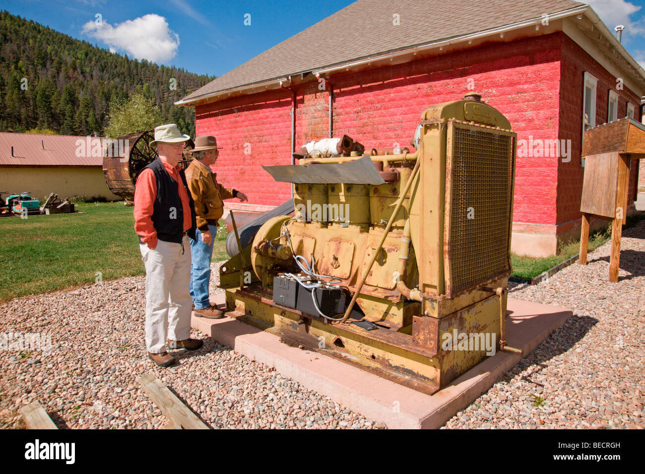 Tourists inspect an old generator used in mining operations around Red ...