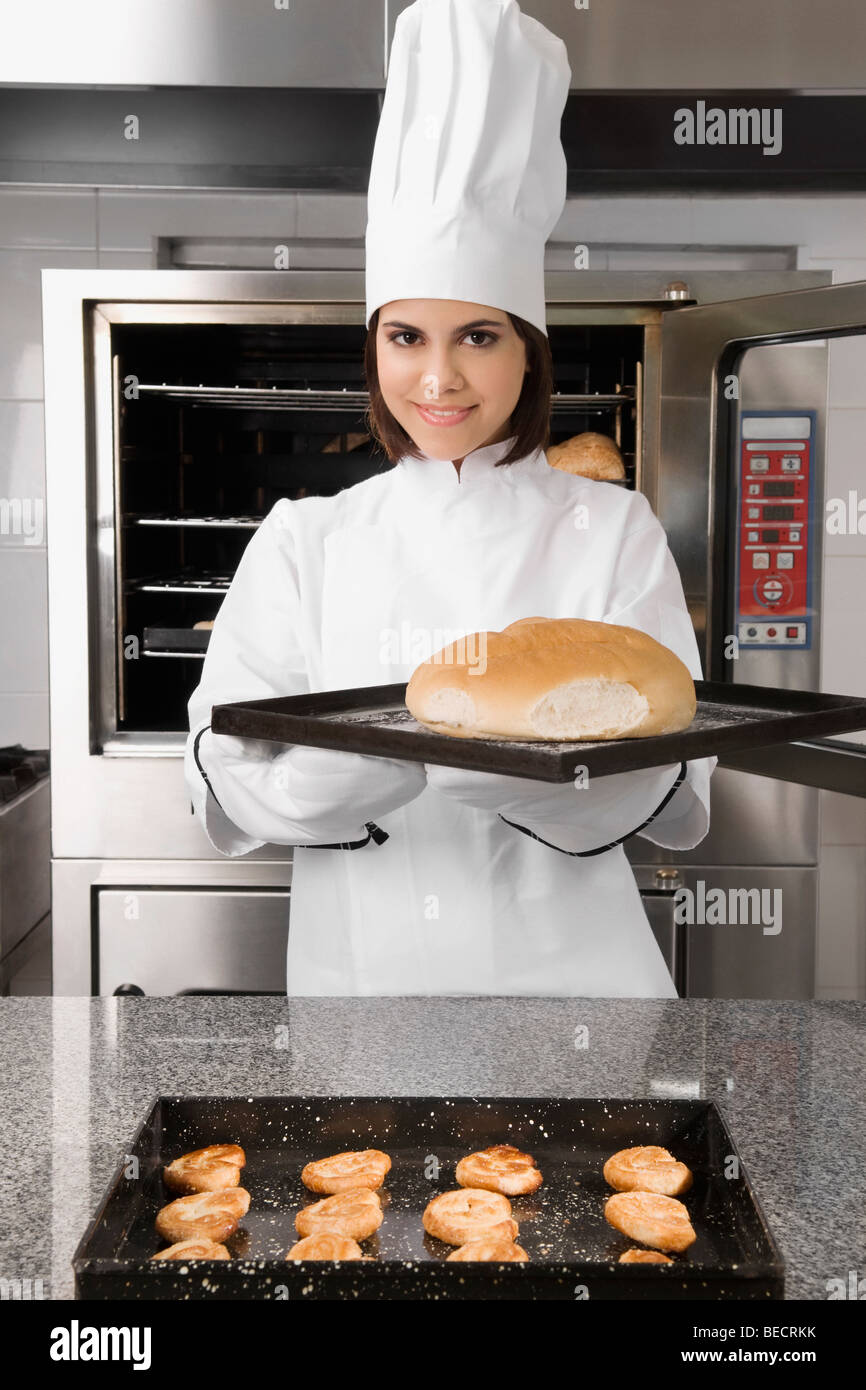 Female chef holding a bun in a tray Stock Photo - Alamy