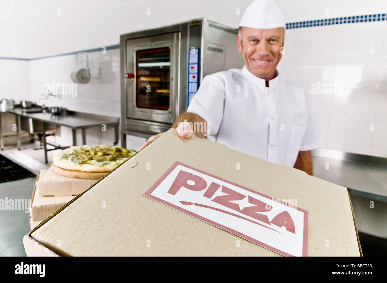 Chef holding a pizza box Stock Photo - Alamy
