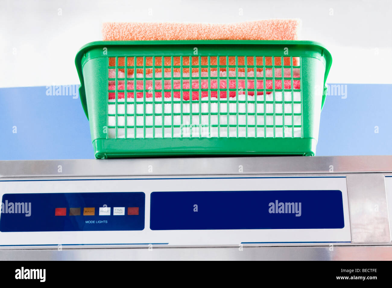 Laundry basket on a washing machine in a laundromat Stock Photo - Alamy