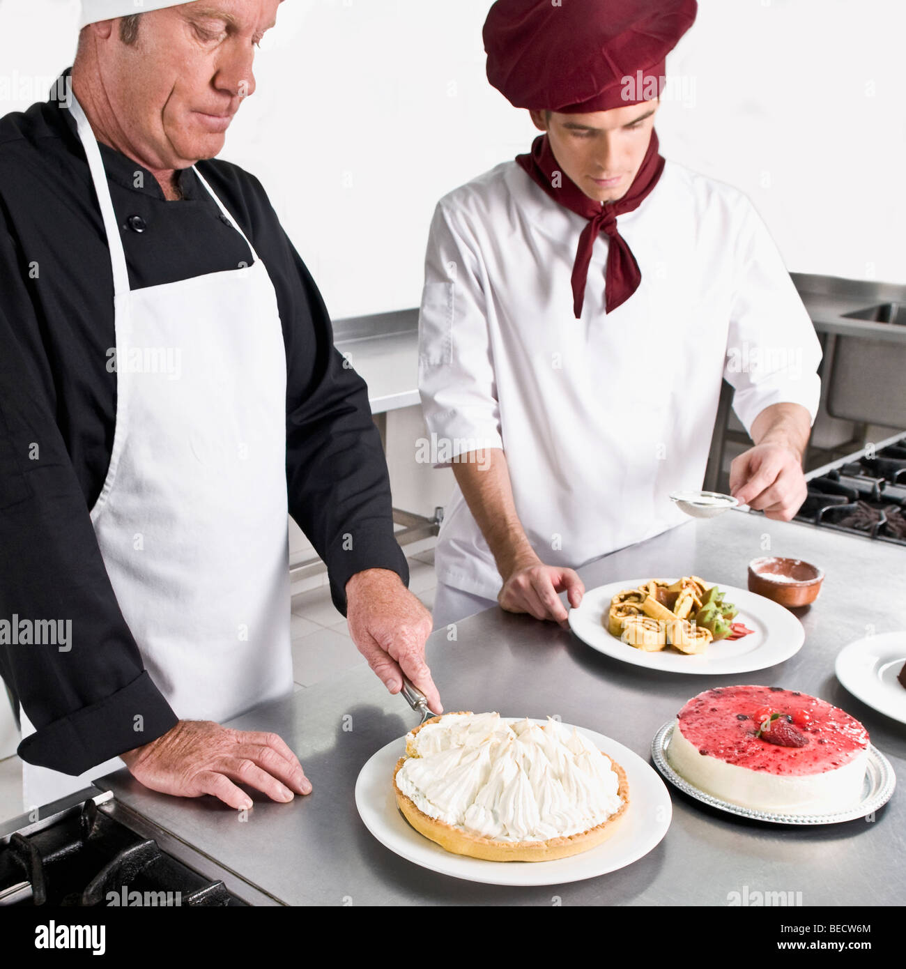 Two chefs cooking food in the kitchen Stock Photo - Alamy