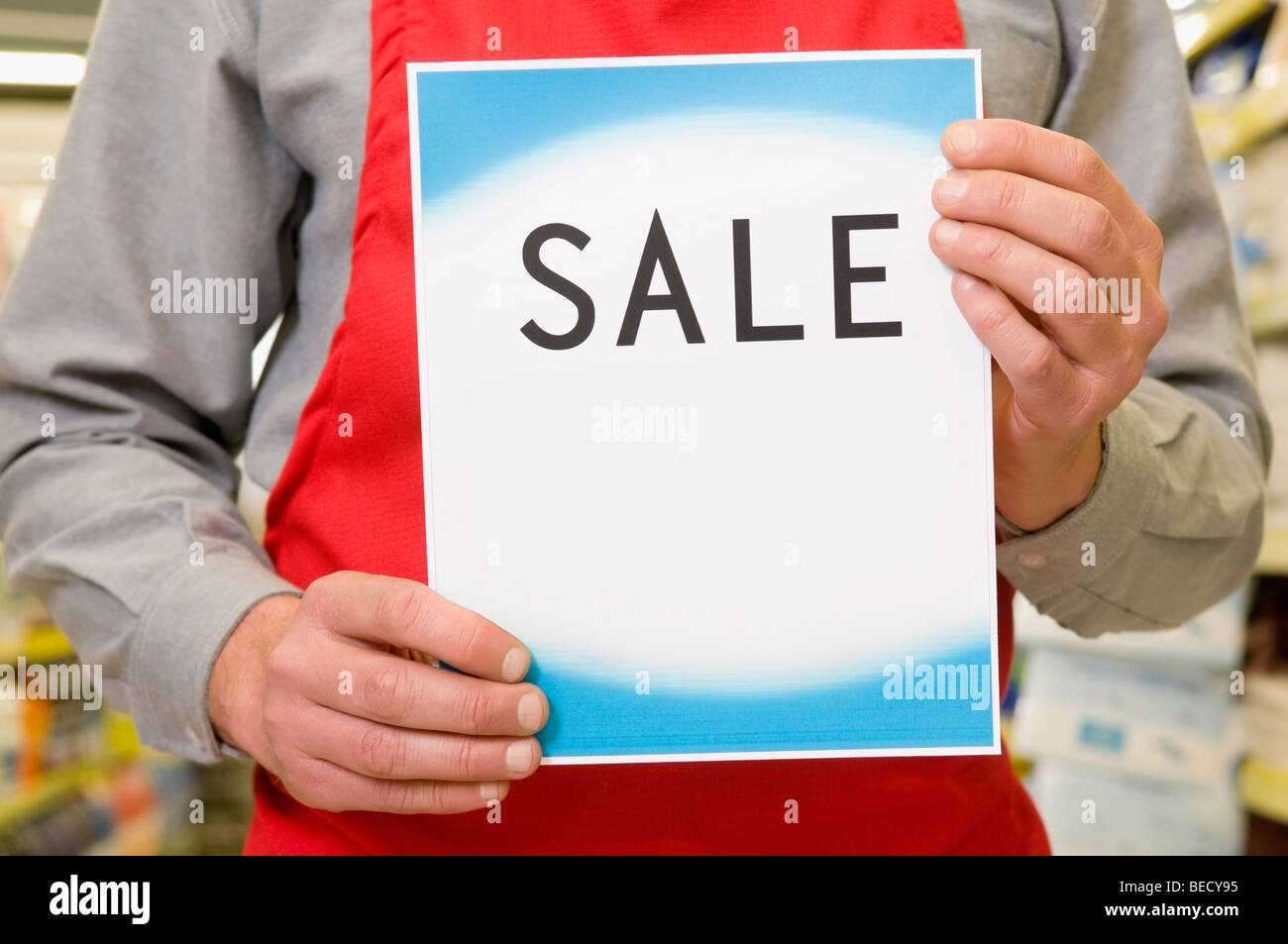 Mid section view of a salesman holding a Sale sign Stock Photo - Alamy