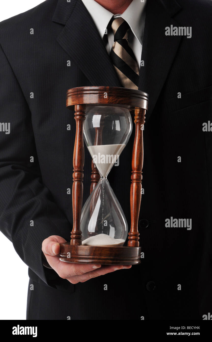 Businessman holding a sand timer isolated against a white background ...