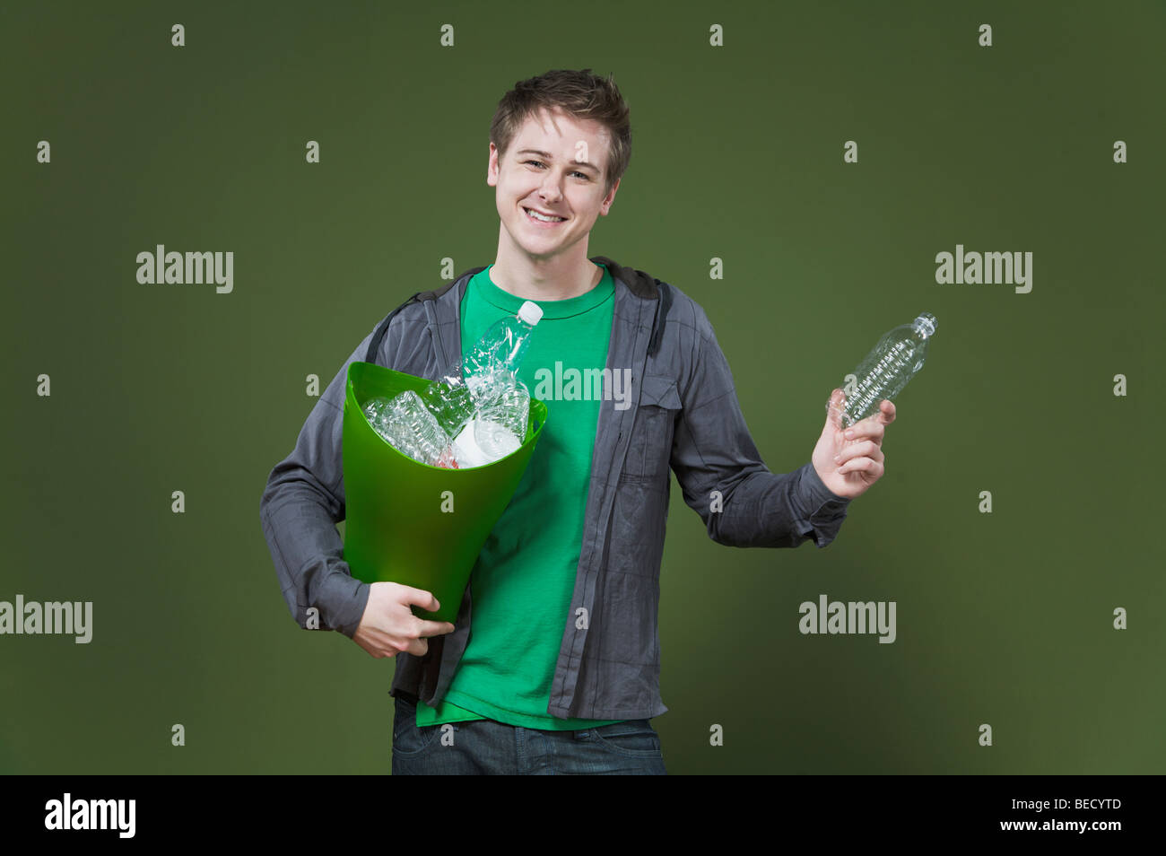 Portrait of a man holding a recycling bin and smiling Stock Photo - Alamy