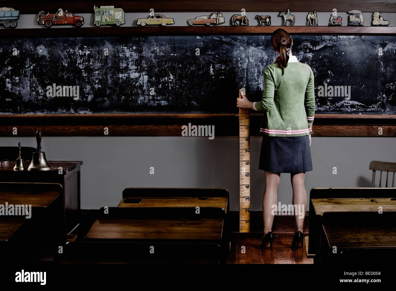 Female teacher holding a ruler in a classroom Stock Photo - Alamy