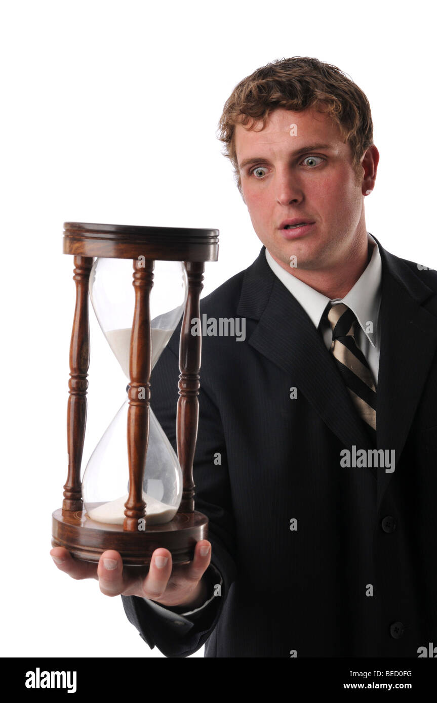 Businessman running out of time holding a sand timer Stock Photo - Alamy