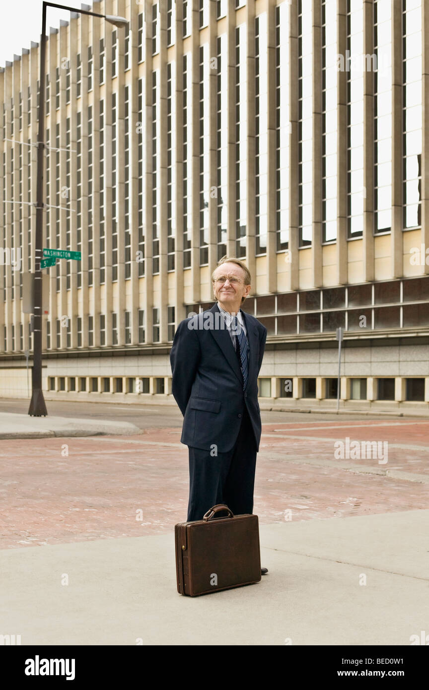 Businessman standing with hands behind back Stock Photo - Alamy