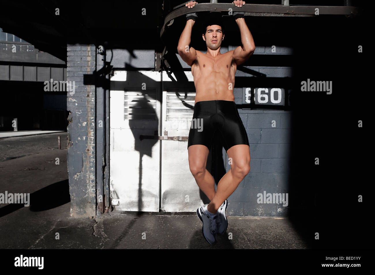 Man doing chin-ups in a street Stock Photo - Alamy
