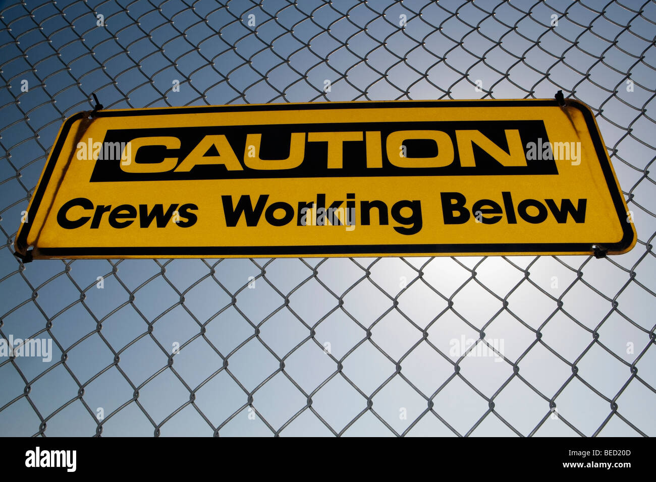 Caution sign on a chainlink fence Stock Photo - Alamy