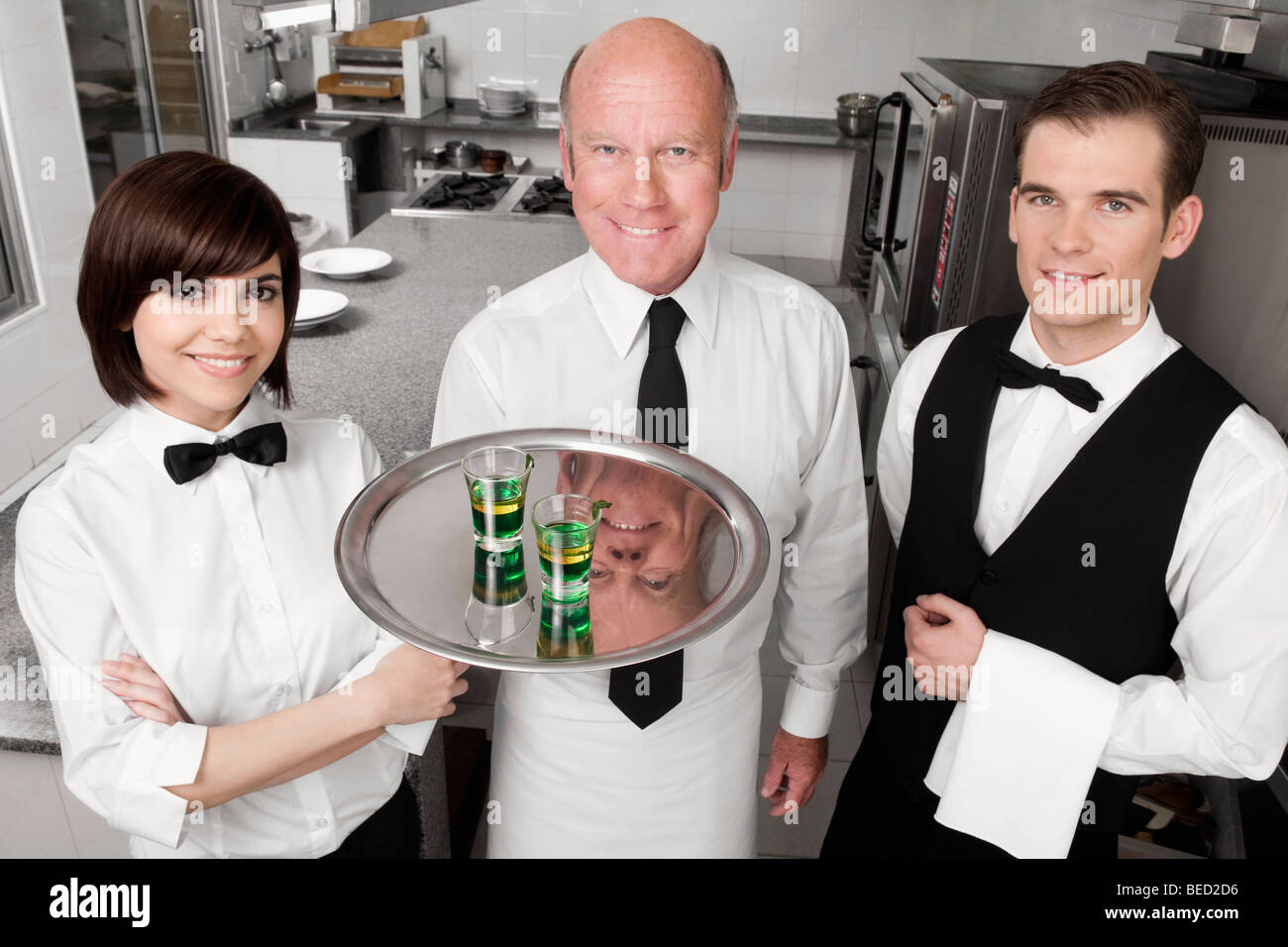 Waiters standing in the kitchen and smiling Stock Photo - Alamy