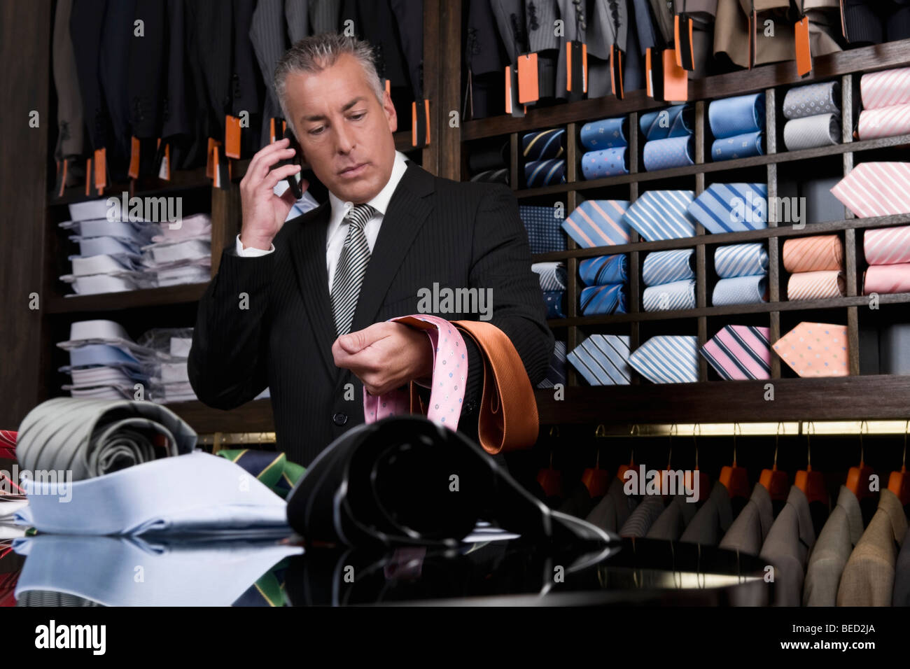 Customer talking on a mobile phone in a clothing store Stock Photo - Alamy